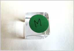 Photograph of an energy cube labeled M.
